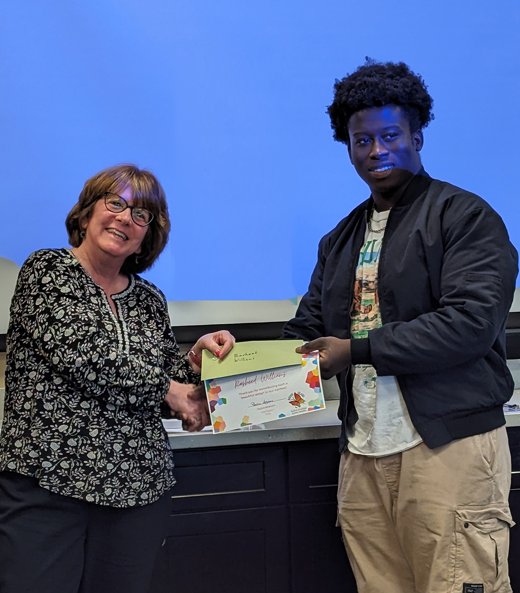 Logo contest runner-up Rasheed Williams receiving his award from RIHGEC ...